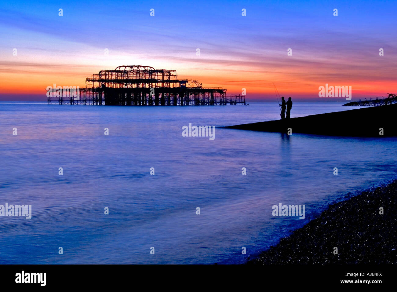 Brighton West Pier ruin after sunset with fisherman visible on launch ...