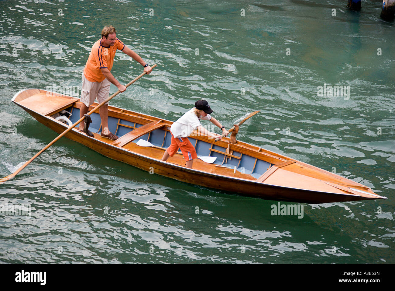 ITALY Veneto Venice Man and young boy rowing a traditional boat in the ...
