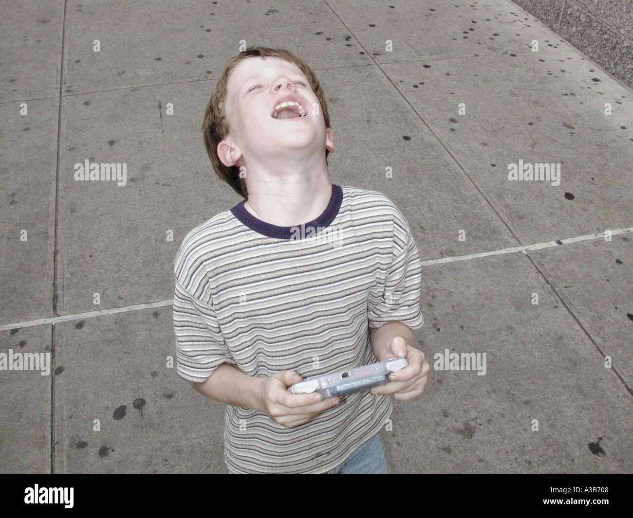 Nine year old caucasian boy playing hand held video game Stock Photo ...