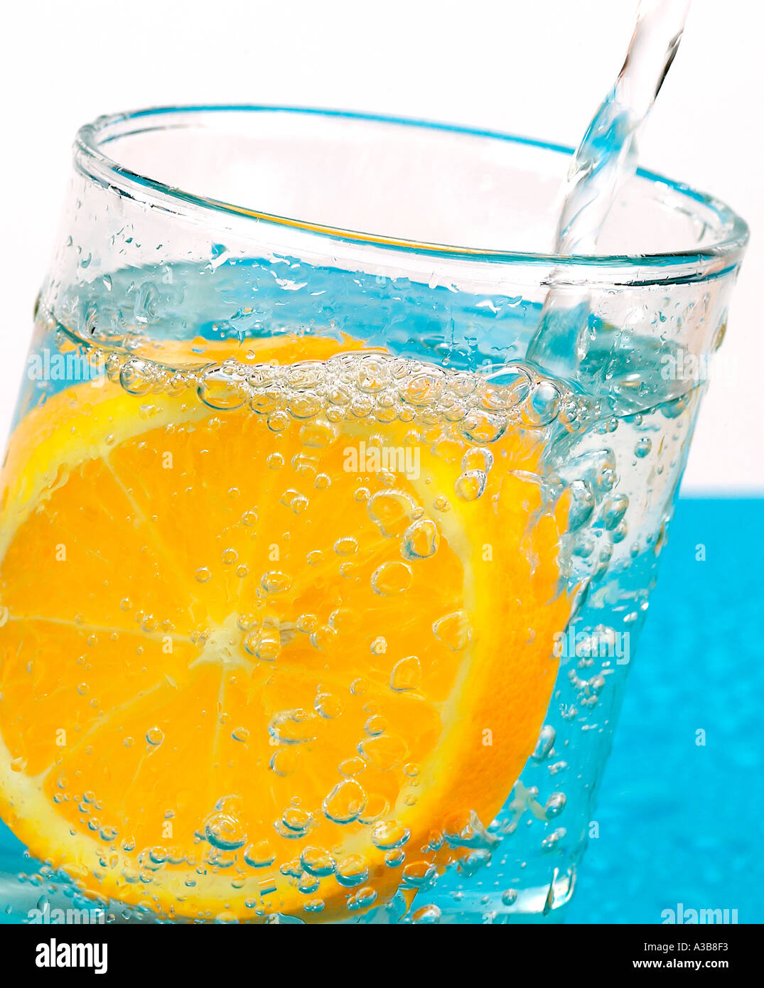 ORANGE SLICE IN GLASS WITH POURING WATER Stock Photo - Alamy