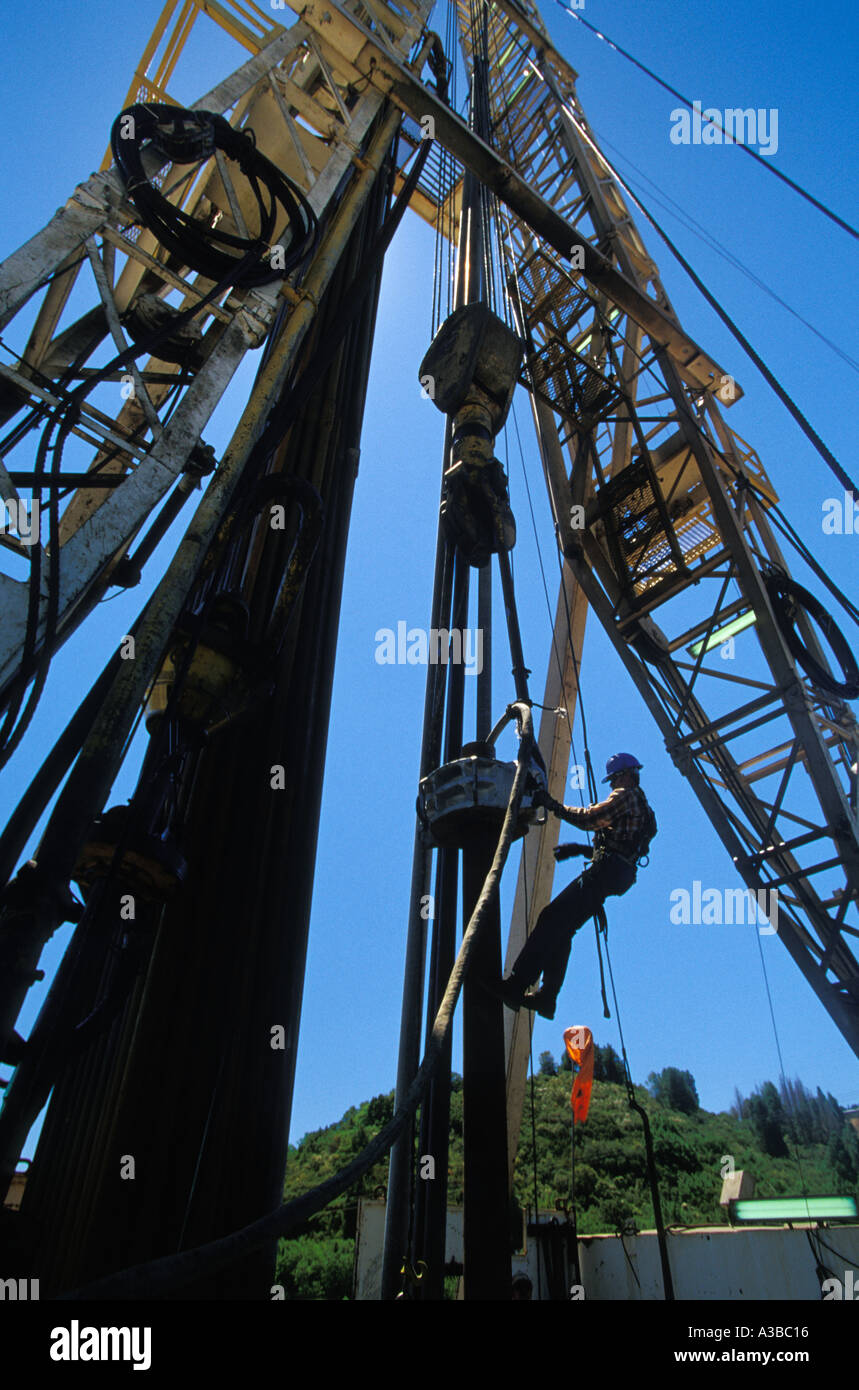 roughneck oil rig worker suspended in bosuns chair working on rig near ...