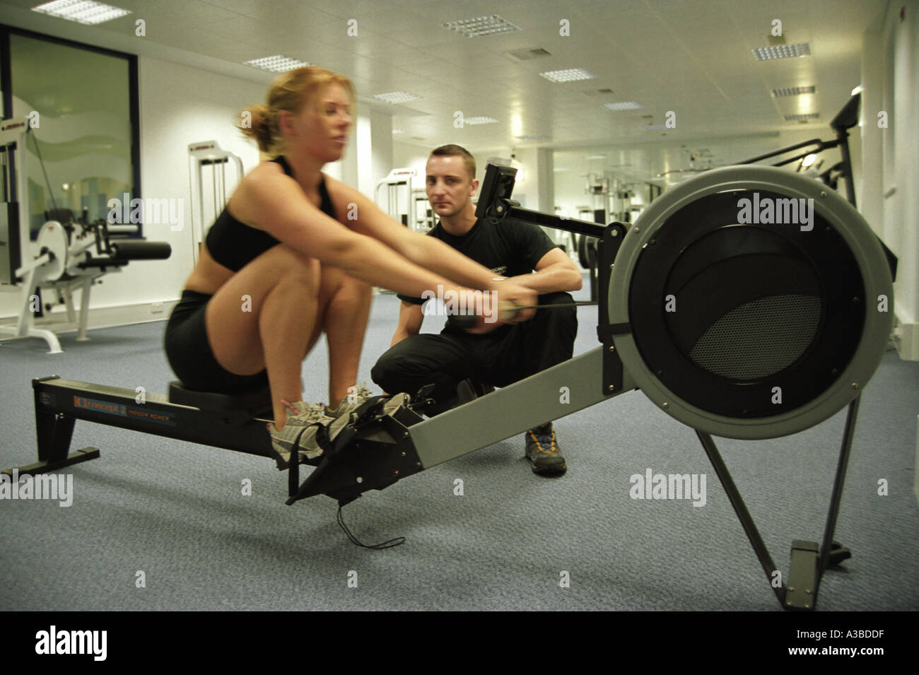 Personal trainer gives rowing instruction to client during a personal ...