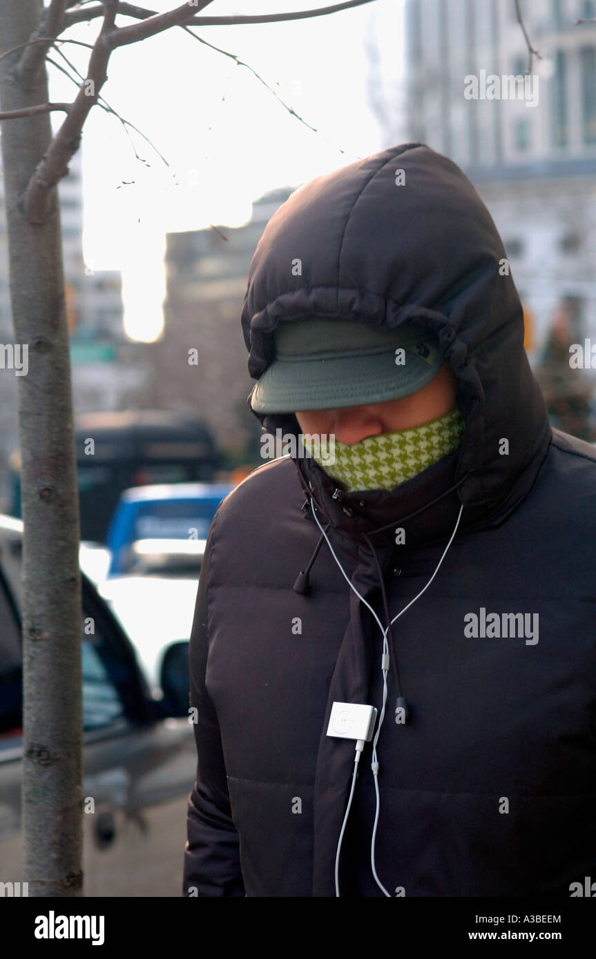 On the coldest day of the year a man is bundled up wearing his iPod ...