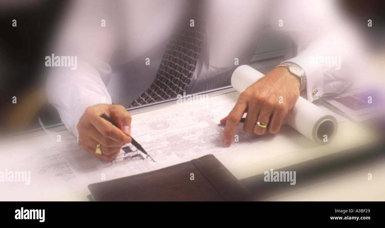 Architect drawing blueprints at work with blur Stock Photo - Alamy