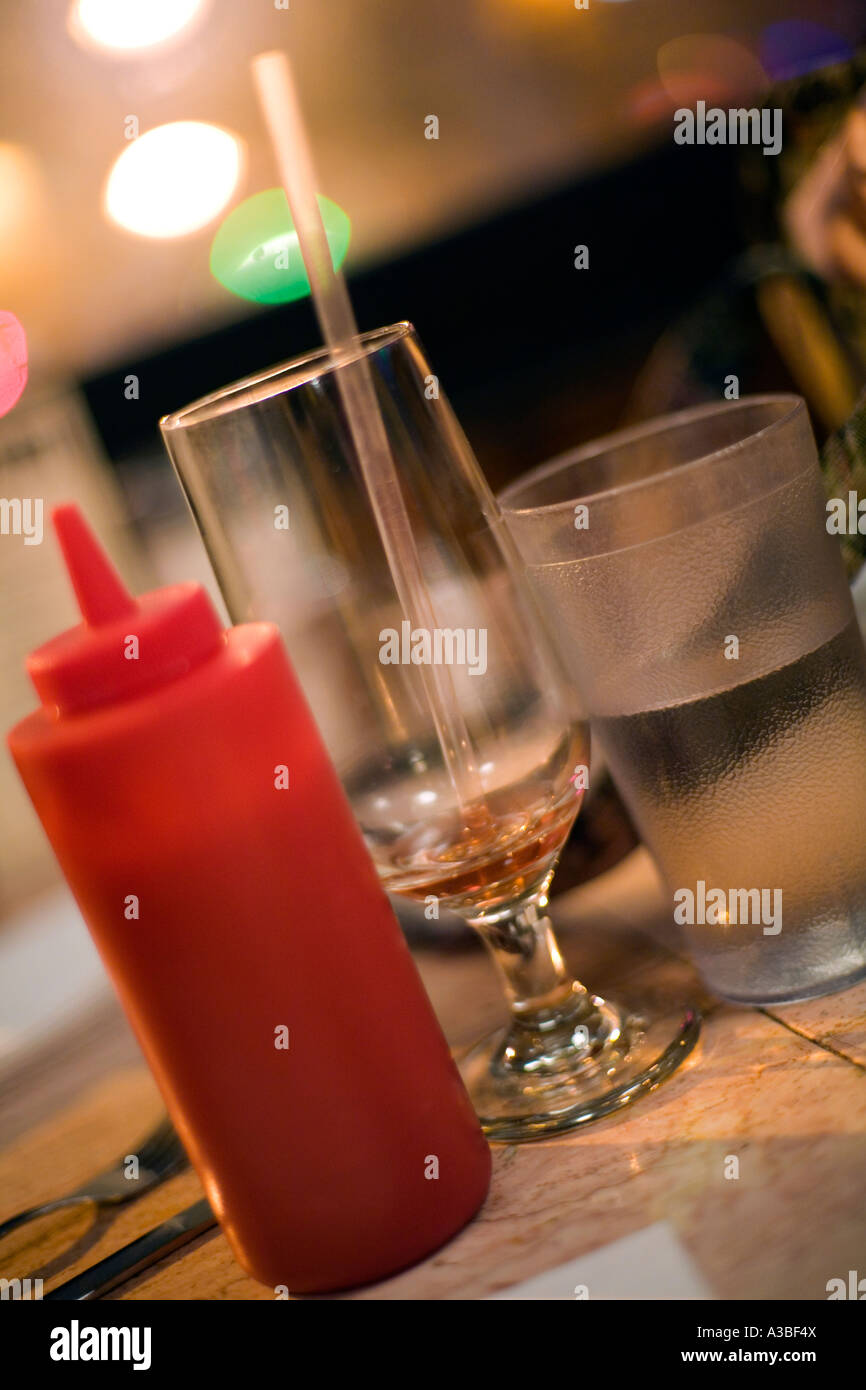 Glass plastic cup and ketchup container on table Stock Photo - Alamy