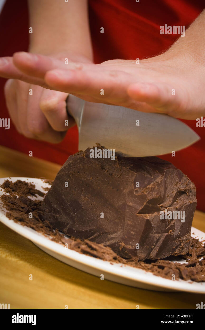 Woman cutting block of chocolate Stock Photo - Alamy