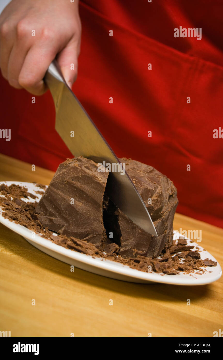 Woman cutting block of chocolate Stock Photo - Alamy
