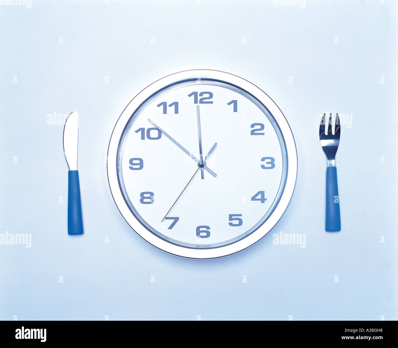 a wall clock with a fork and a knife Stock Photo - Alamy