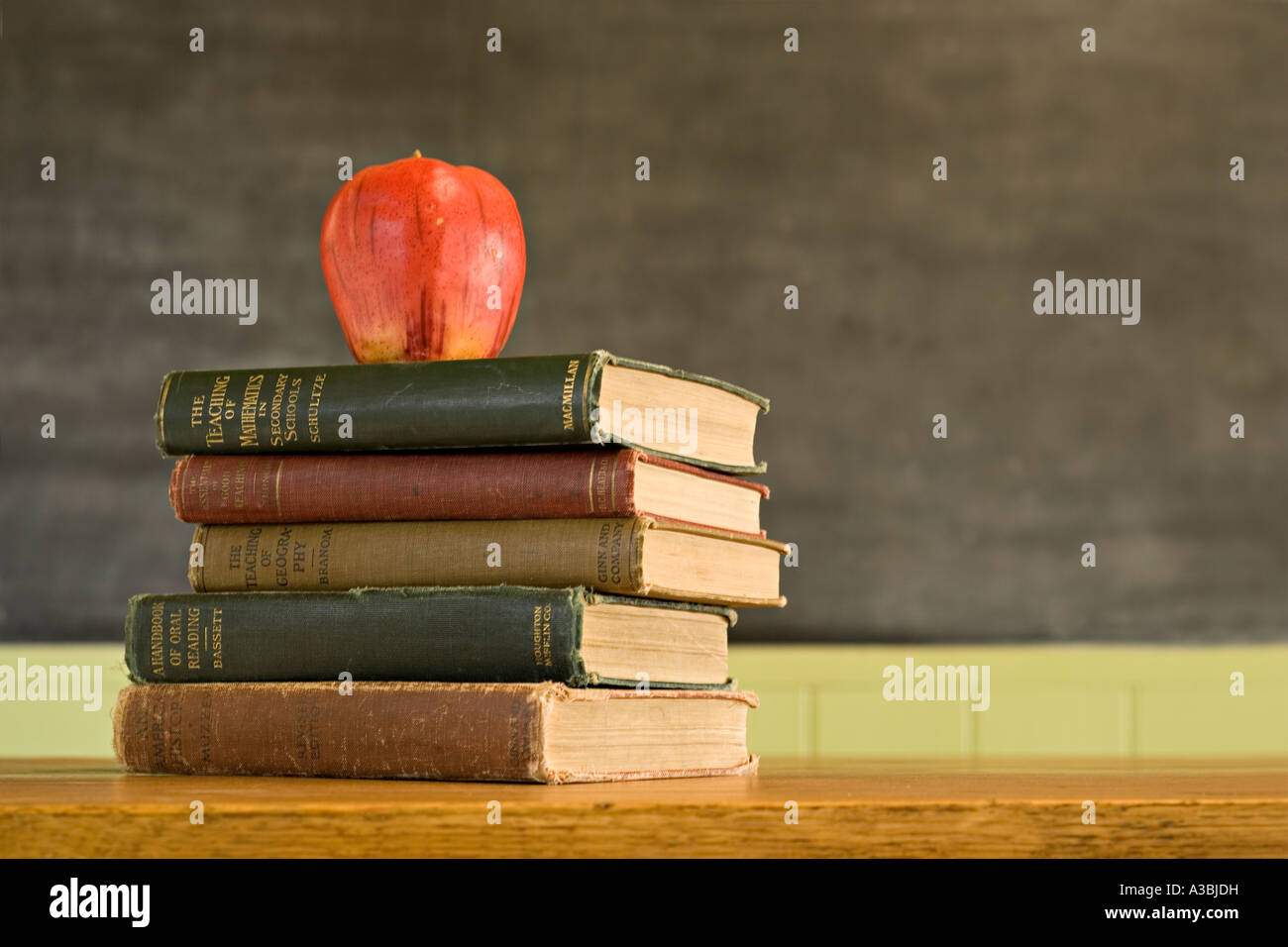 Back to school books on desk with apple and chalkboard Stock Photo - Alamy