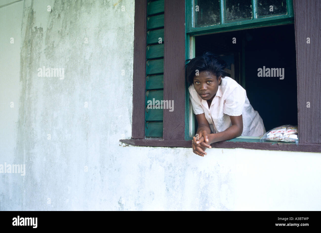 young jamaican woman standing at window in house Stock Photo - Alamy