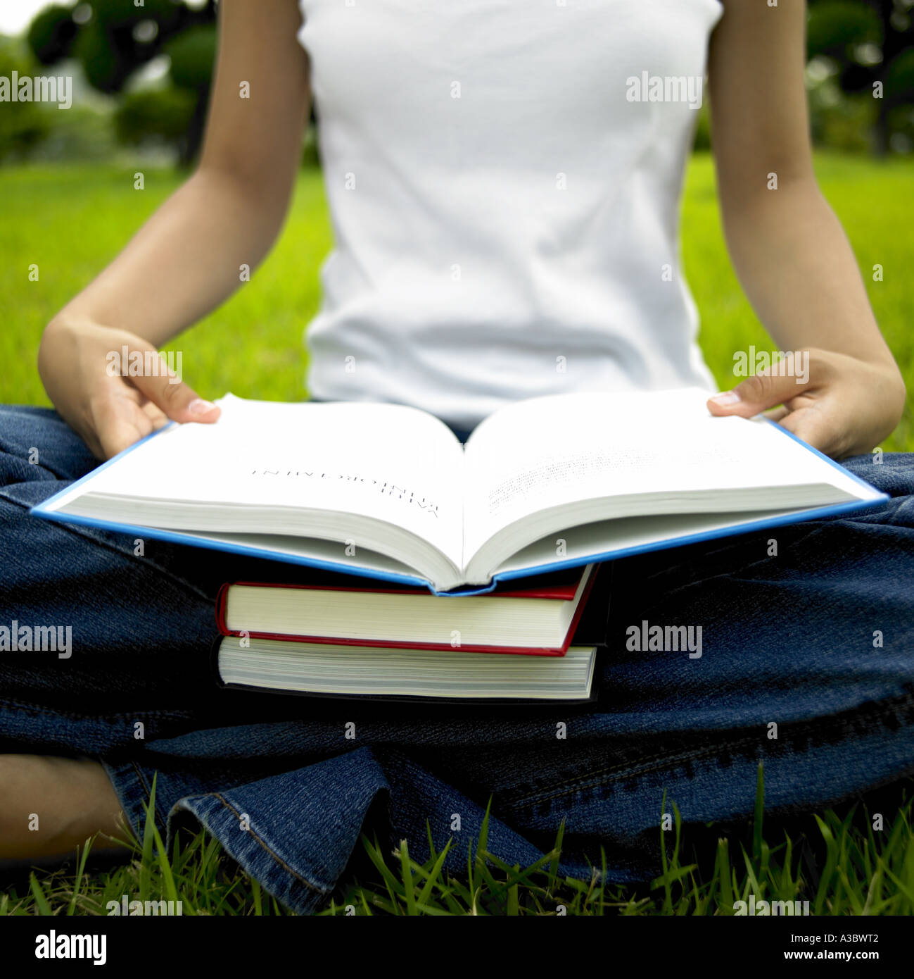 a girl is sitting tall, reading books Stock Photo - Alamy