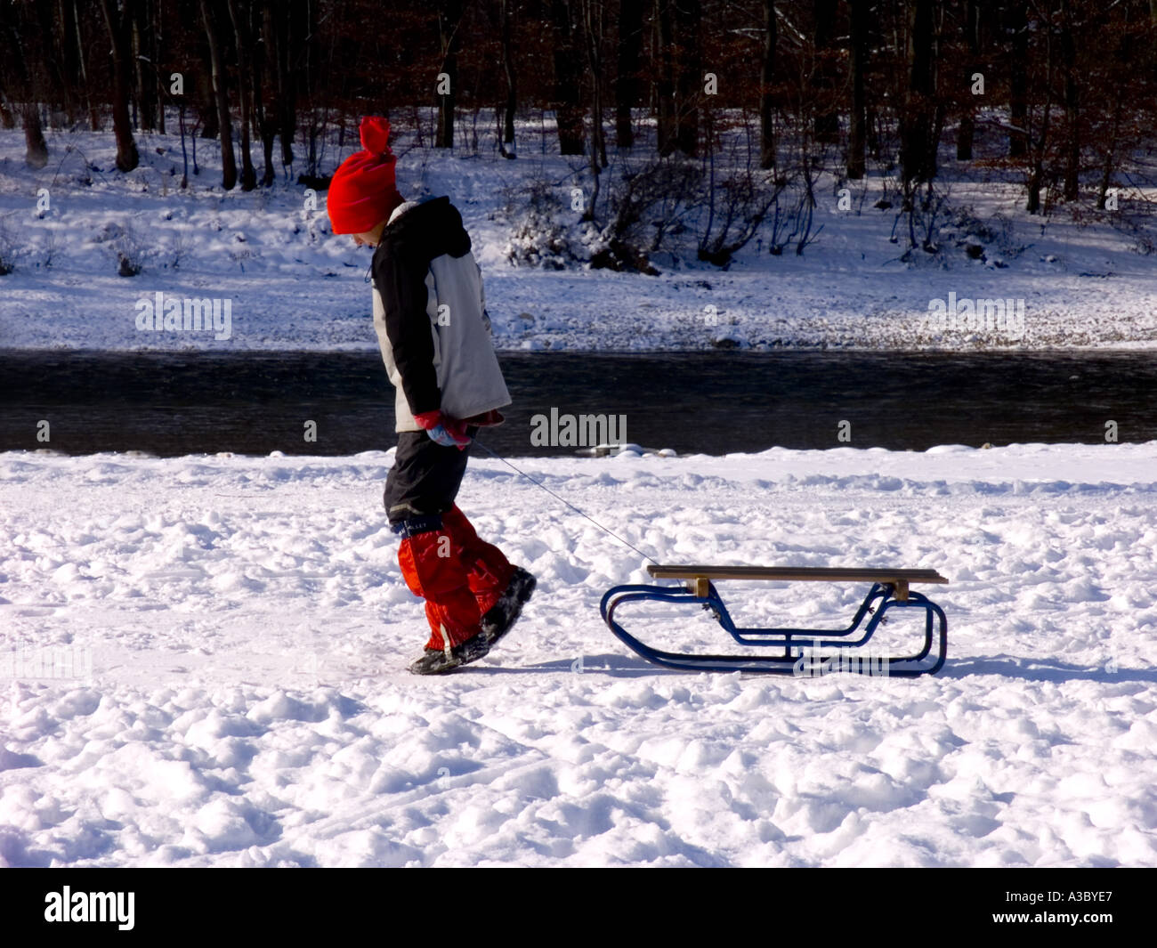 Child Kid pushing pulling sledge in deep winter Stock Photo - Alamy
