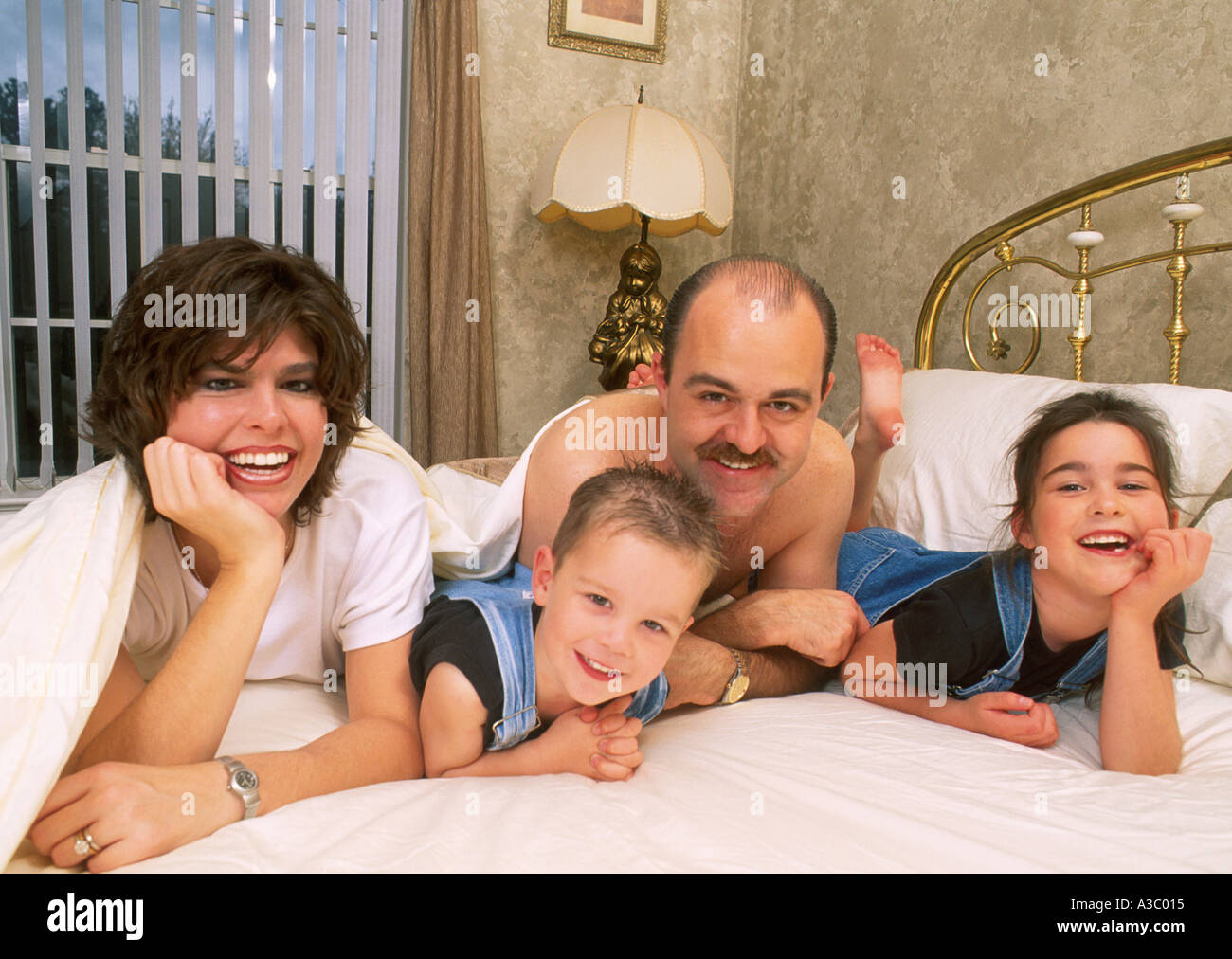 Hispanic Family Playful in bed Stock Photo - Alamy