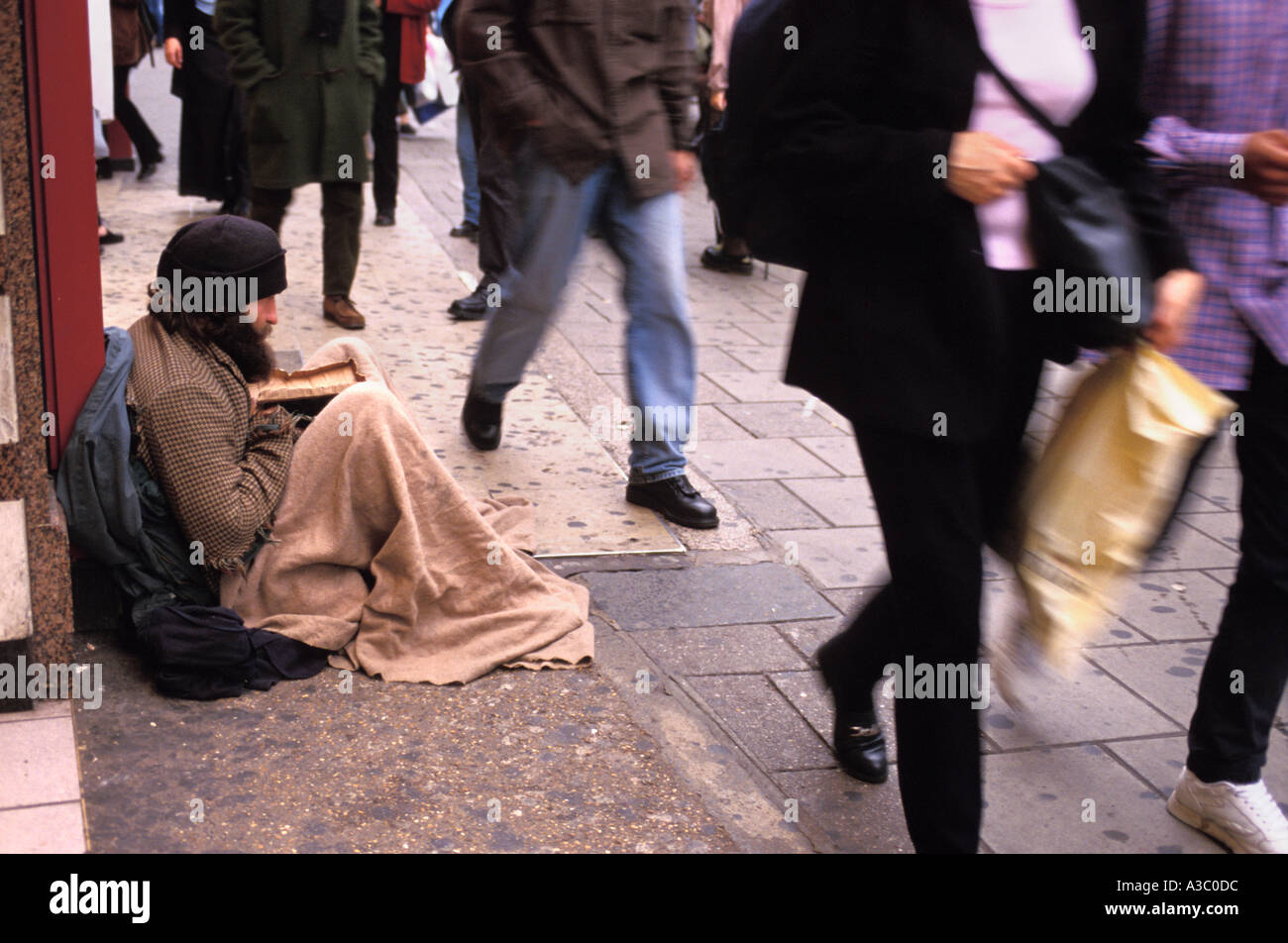 People walk past homeless man begging street in London England UK Stock ...