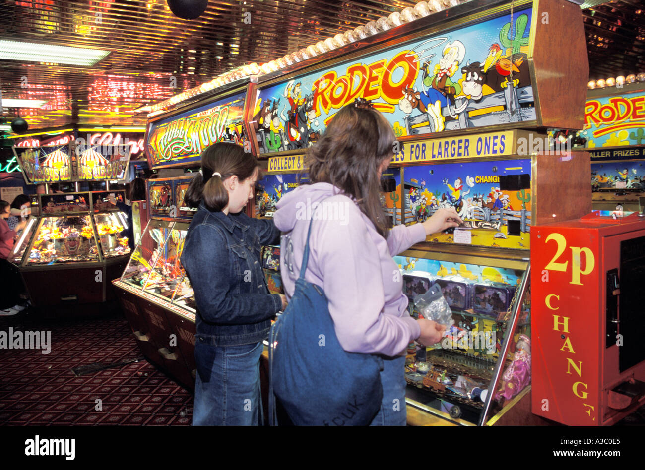 Girls playing on the penny slot machines in an amusement arcade ...