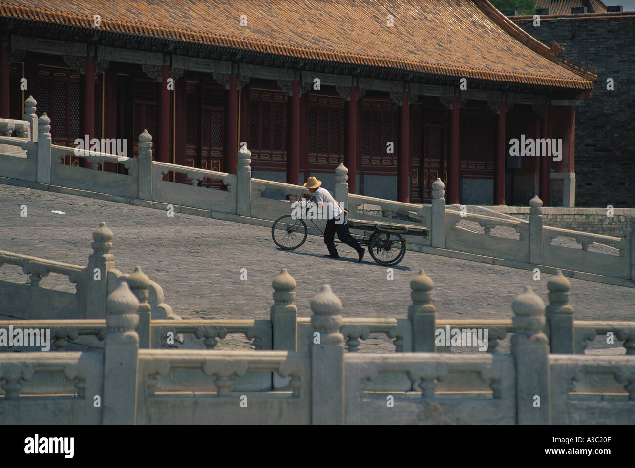 Man pushing bicycle up an inclined road in the Forbidden City in ...