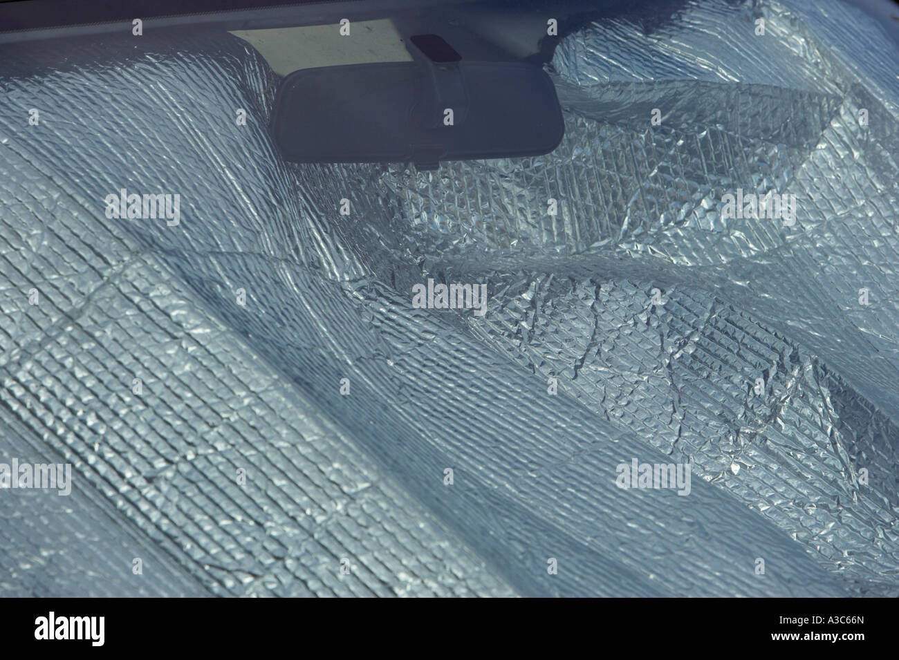 silver sun reflector windscreen visor protector placed in car window ...