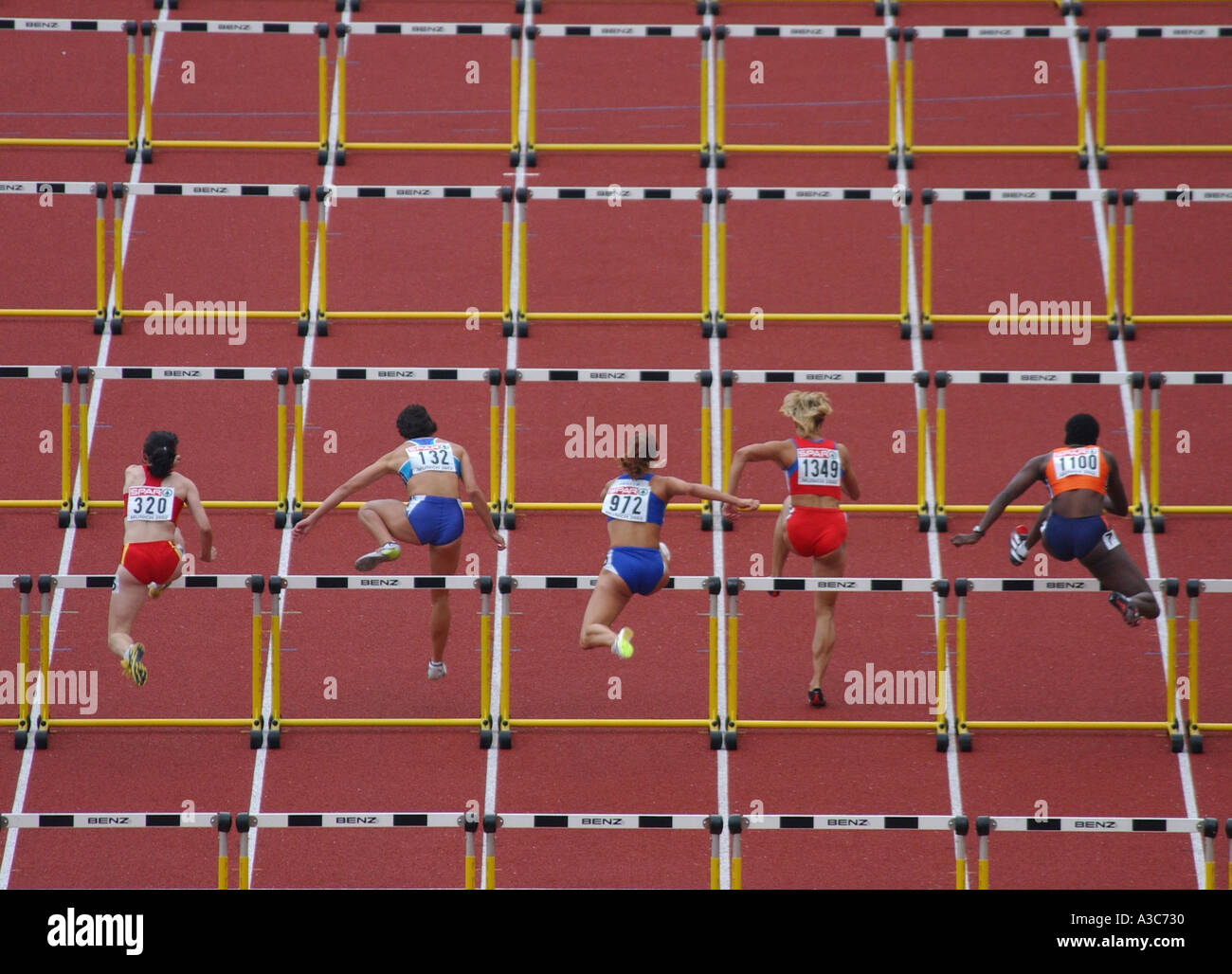 female runners jumping the obstacle of a 100m hurdles race at the ...