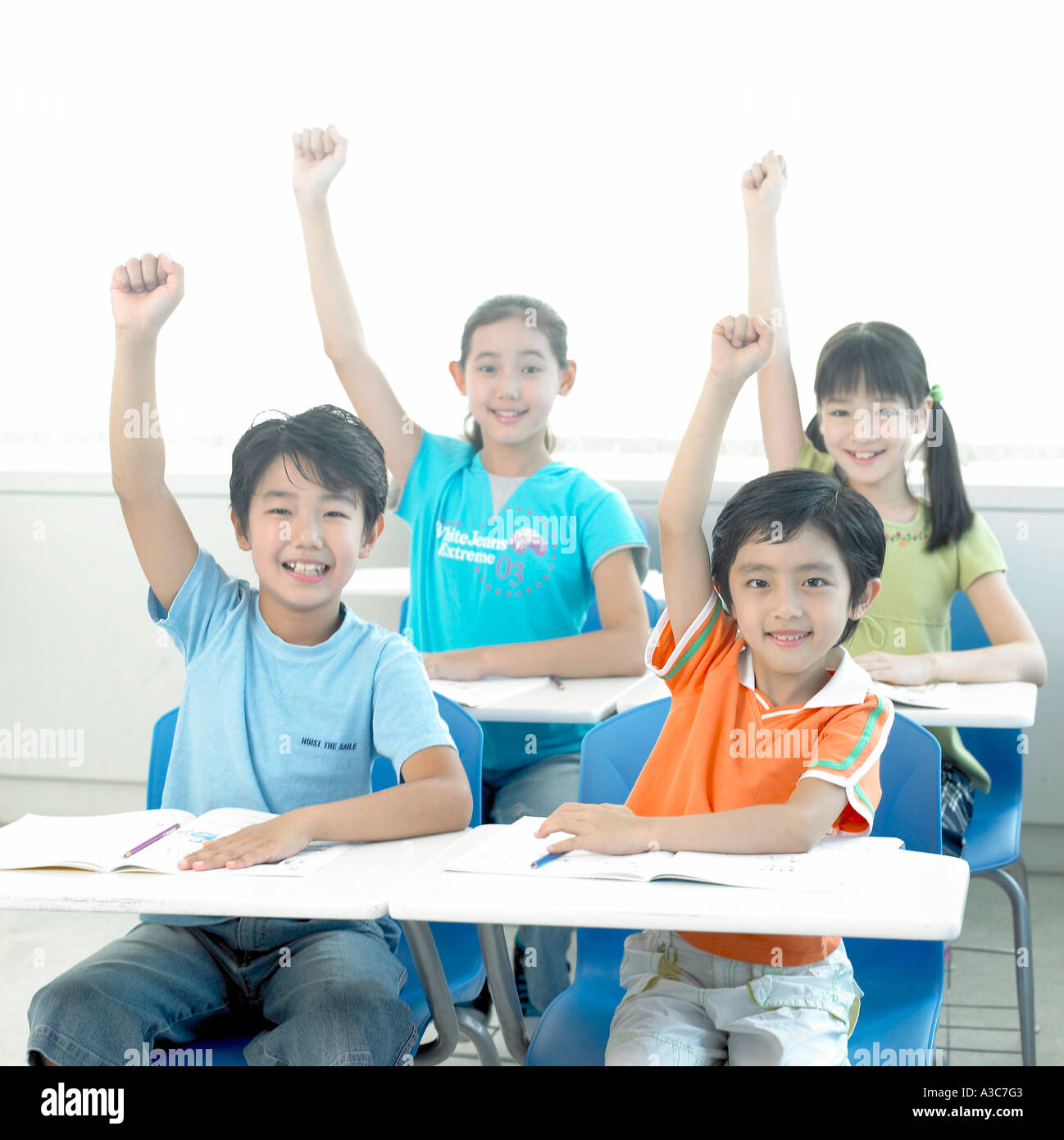 Four children raising their hands Stock Photo - Alamy