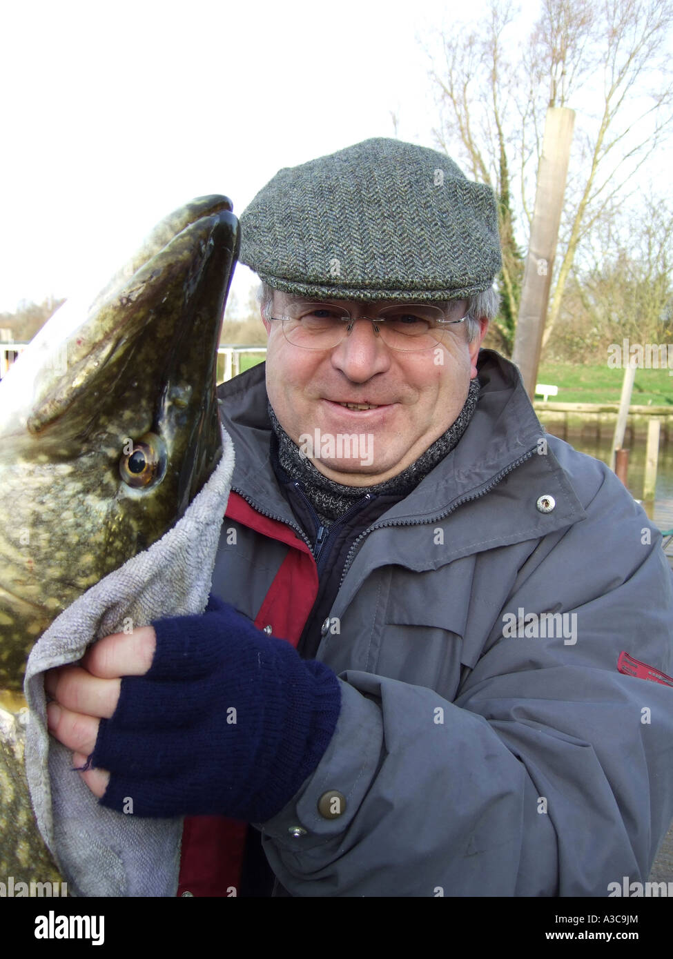 smiling middle aged man with freshly caught large pike Stock Photo - Alamy