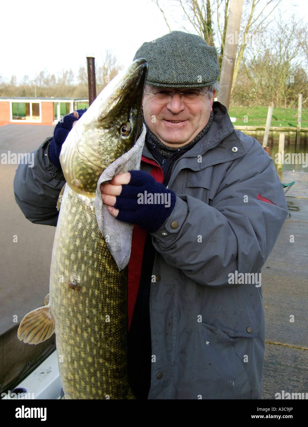 smiling middle aged fisherman with pike Stock Photo - Alamy