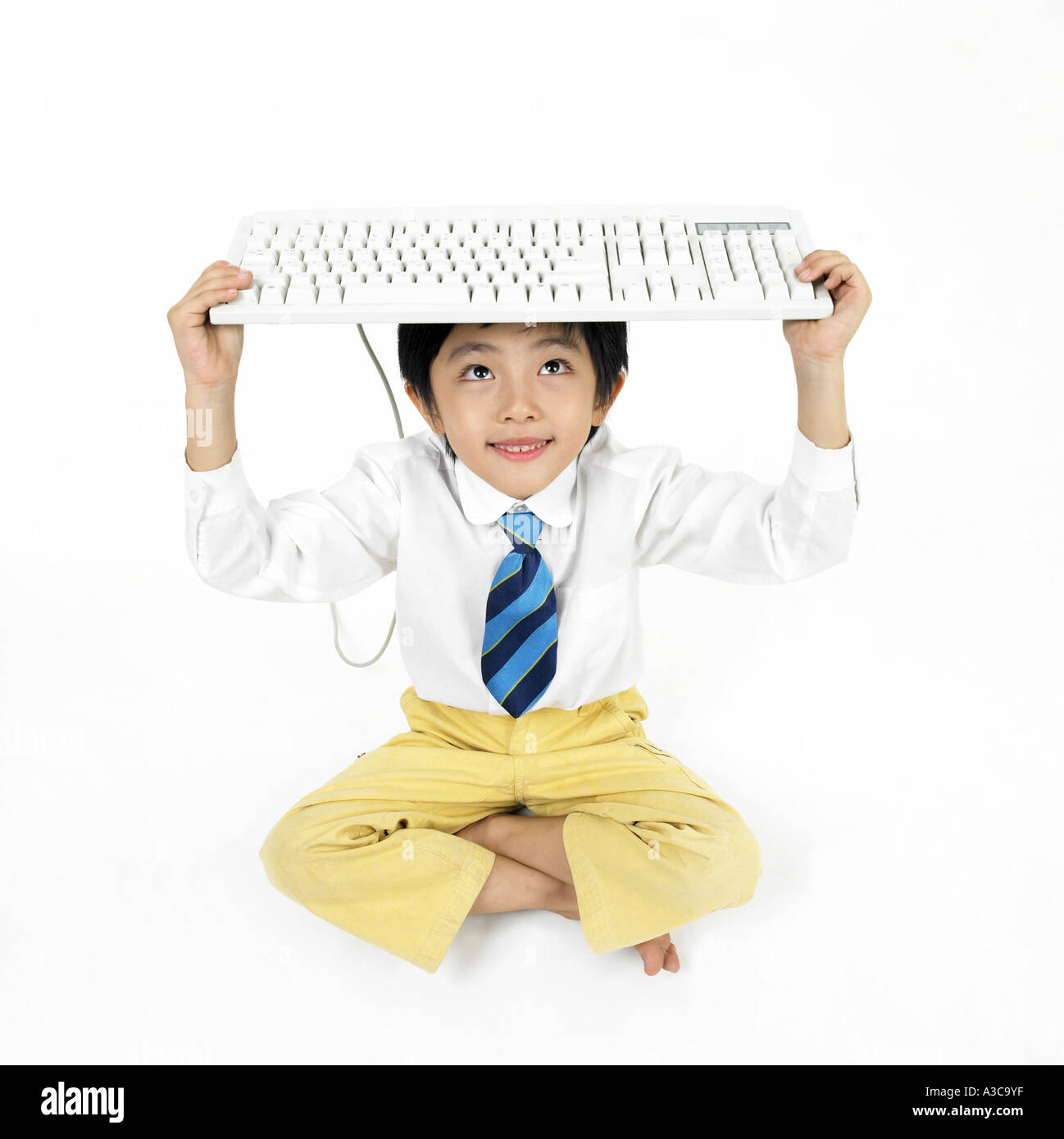 Boy putting keyboard on his head Stock Photo - Alamy