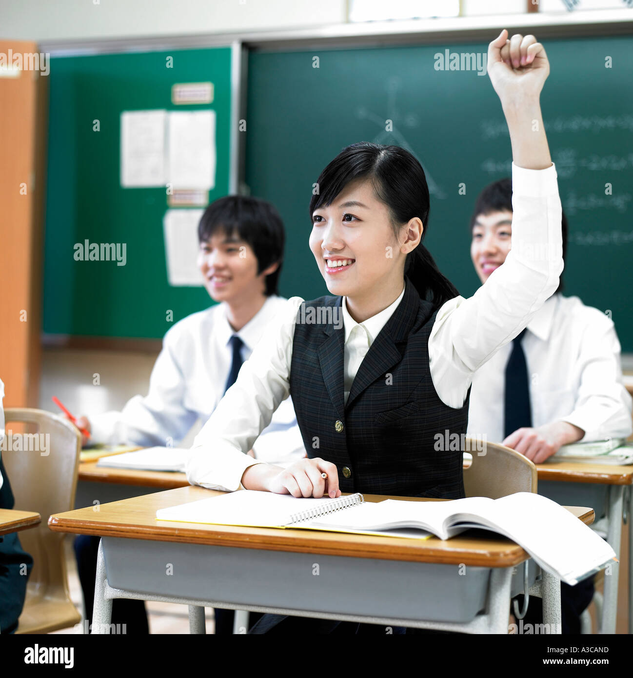 A student raising her hand Stock Photo - Alamy