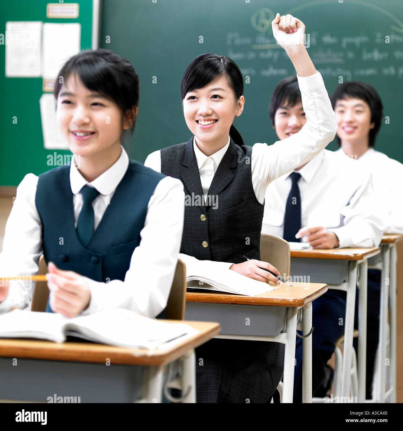 A student raising her hand Stock Photo - Alamy