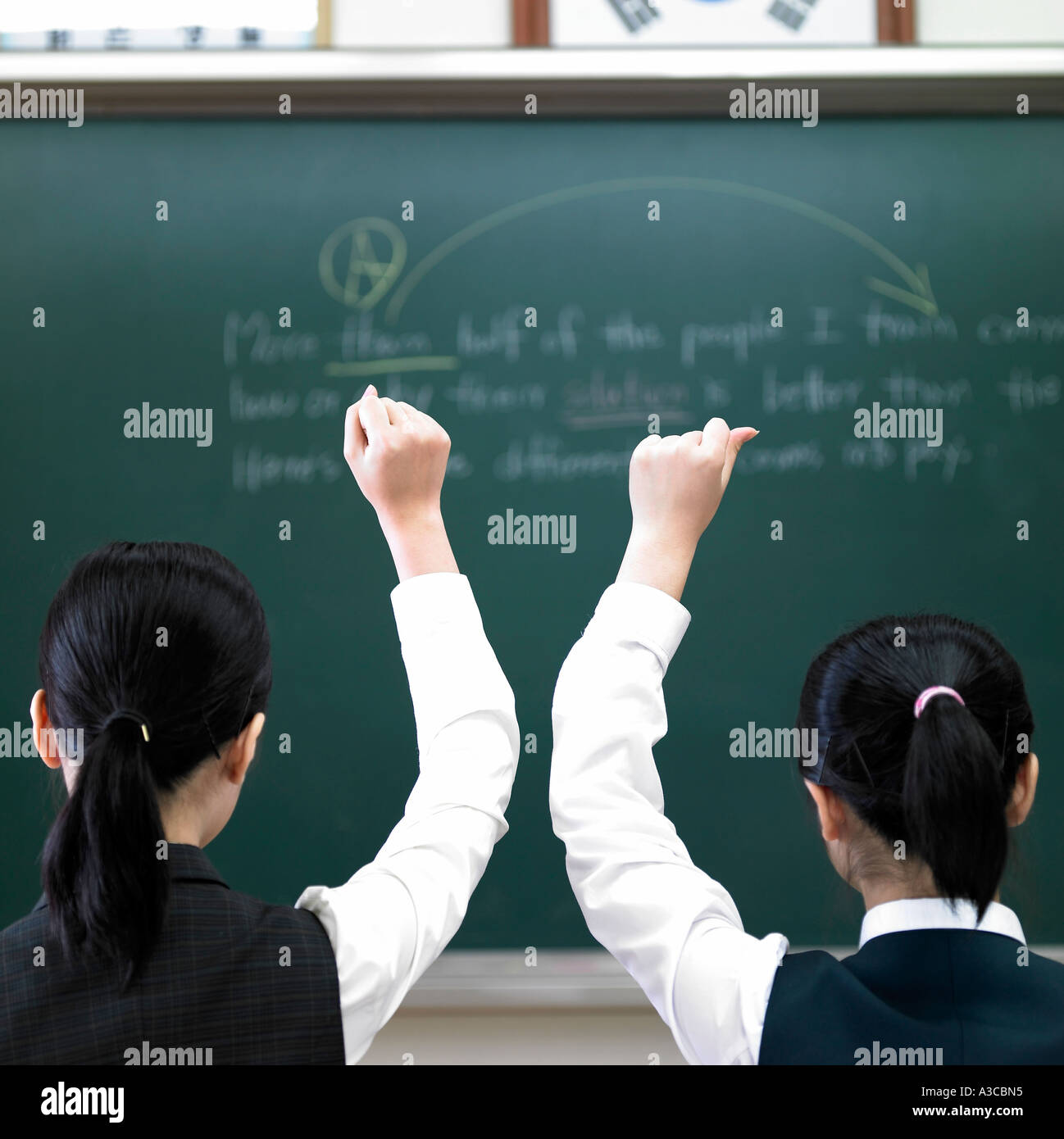 Two students rasing their hands Stock Photo - Alamy