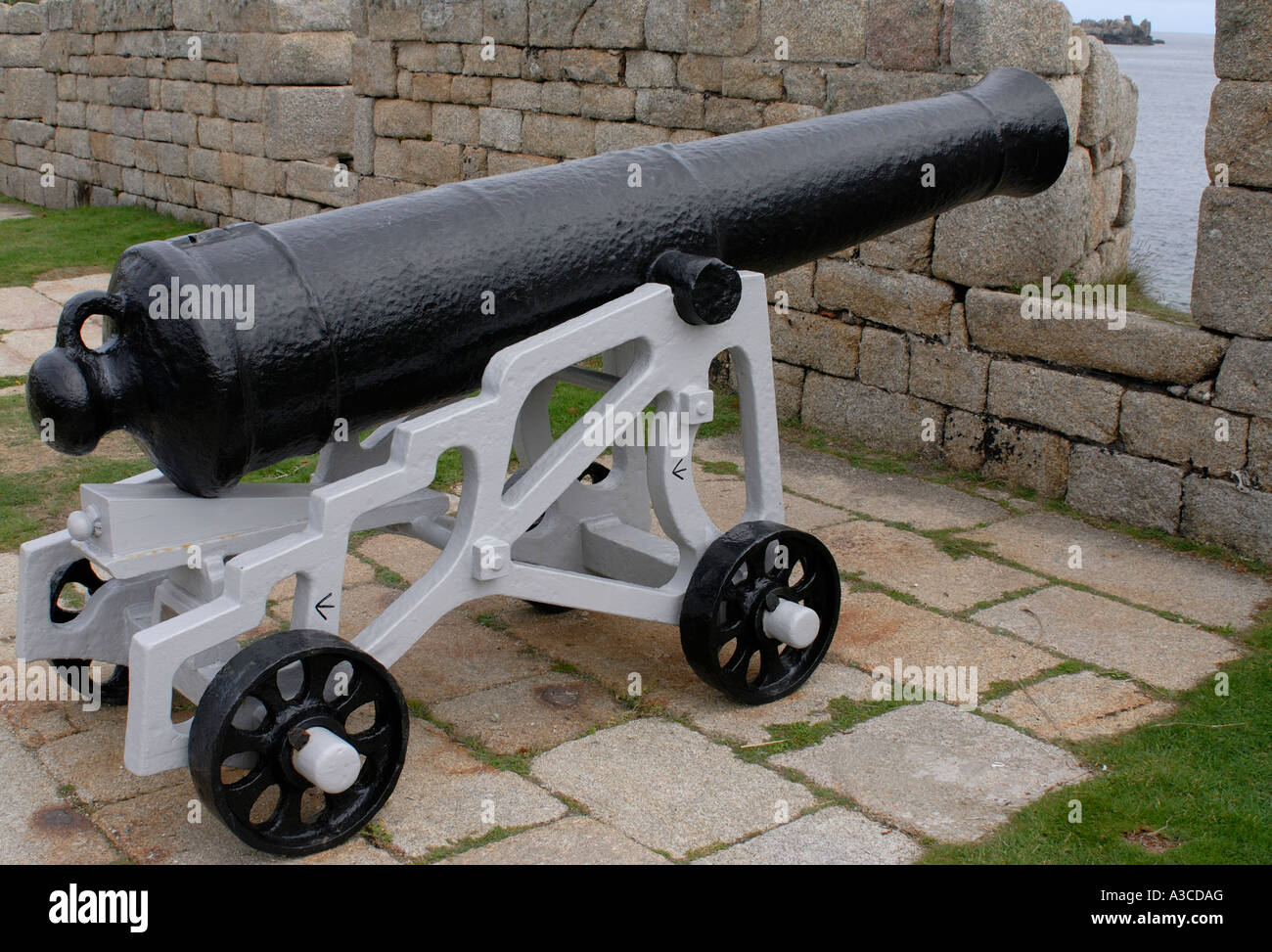 An eighteenth century cast iron cannon stands by the granite walls of a ...