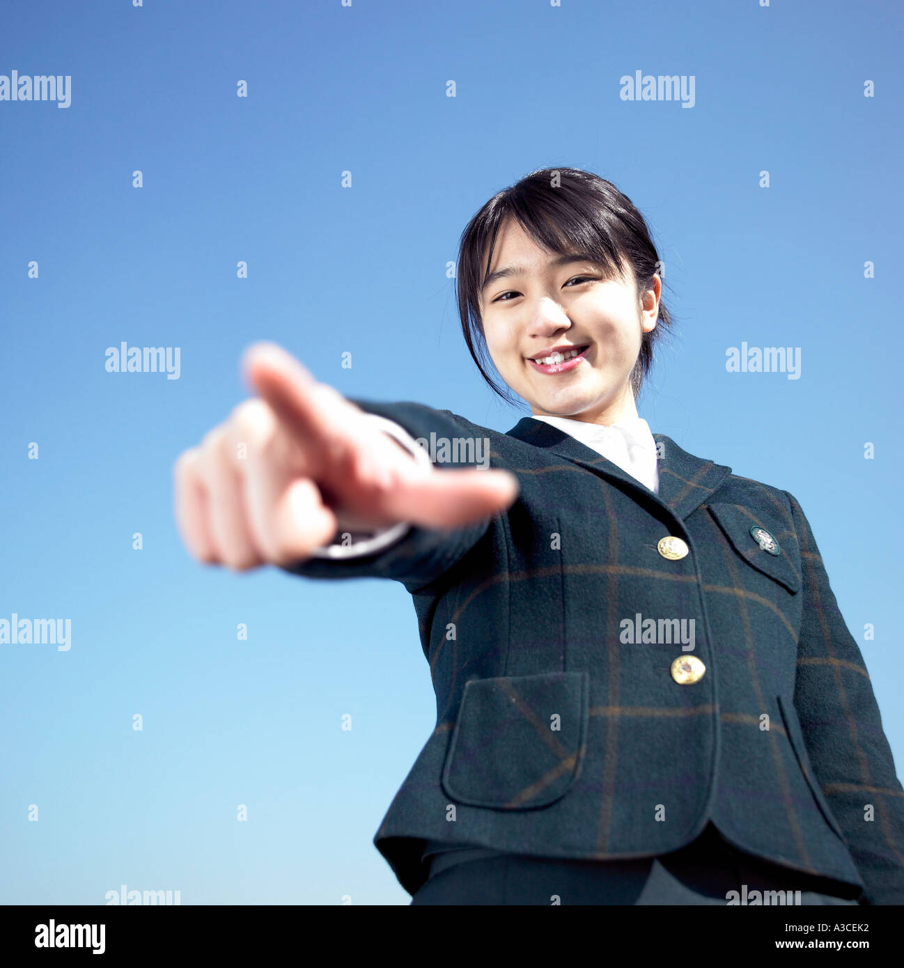 A student in a school uniform is pointing at something Stock Photo - Alamy
