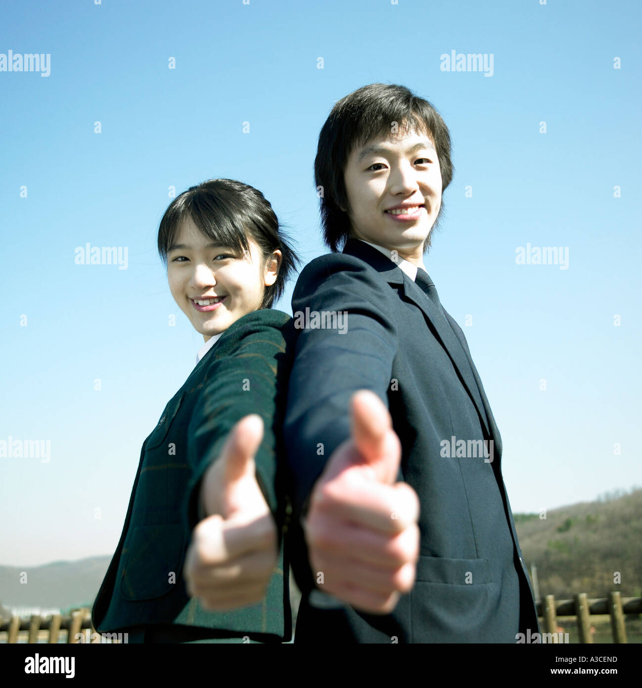 Two teenagers are smiling with their thumbs up Stock Photo - Alamy