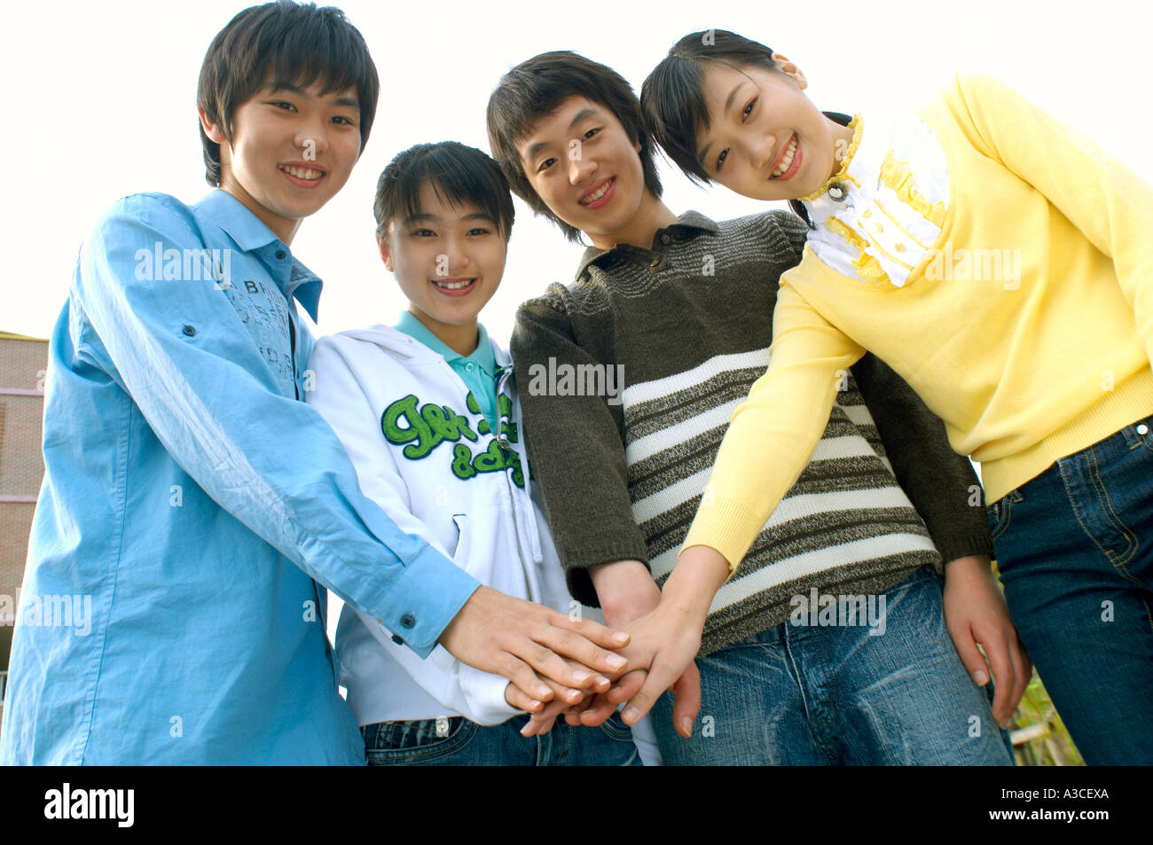 four teenagers are putting their hands low together Stock Photo - Alamy