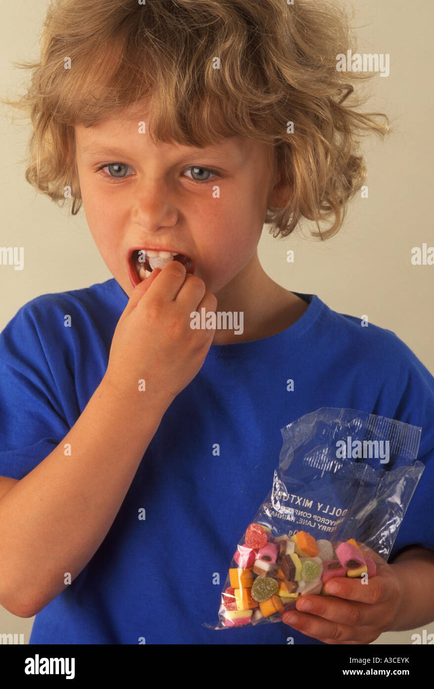 little girl eating a bag of dolly mixtures Stock Photo - Alamy