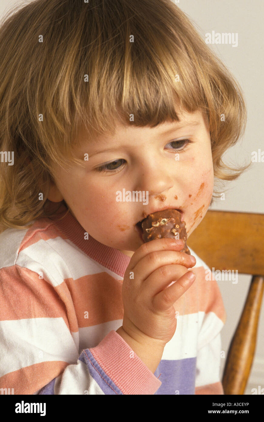 little girl eating a bar of chocolate Stock Photo - Alamy