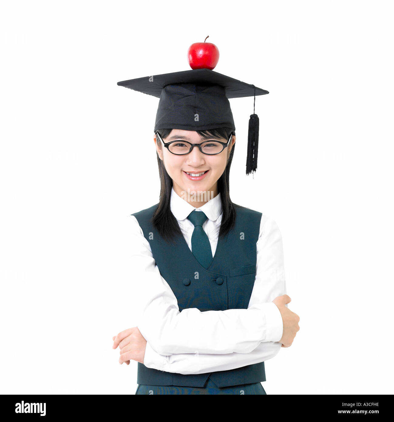 A female student in a school uniform is wearing a graduation cap and ...