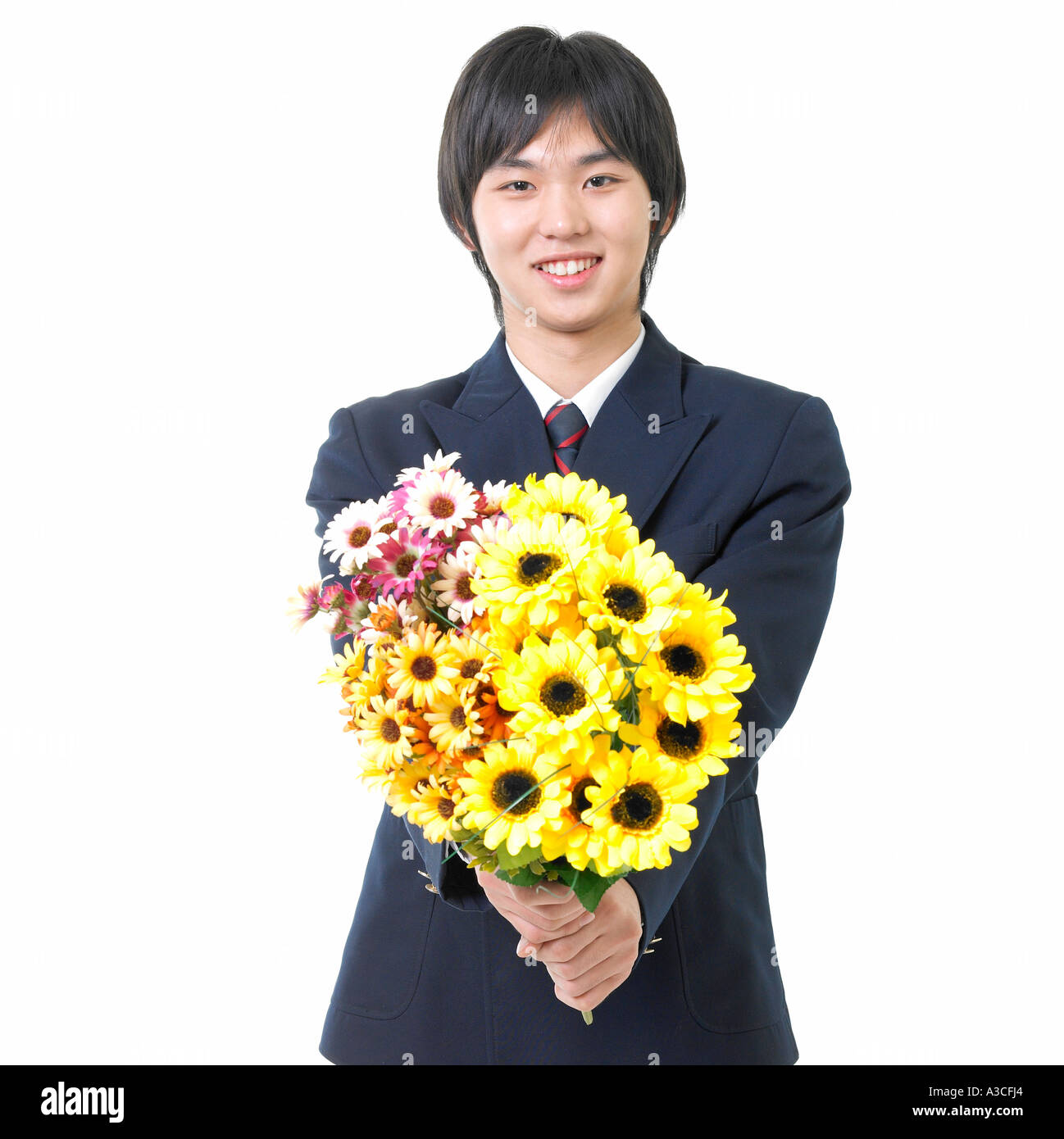 A male student in a school uniform is giving colorful flowers Stock ...