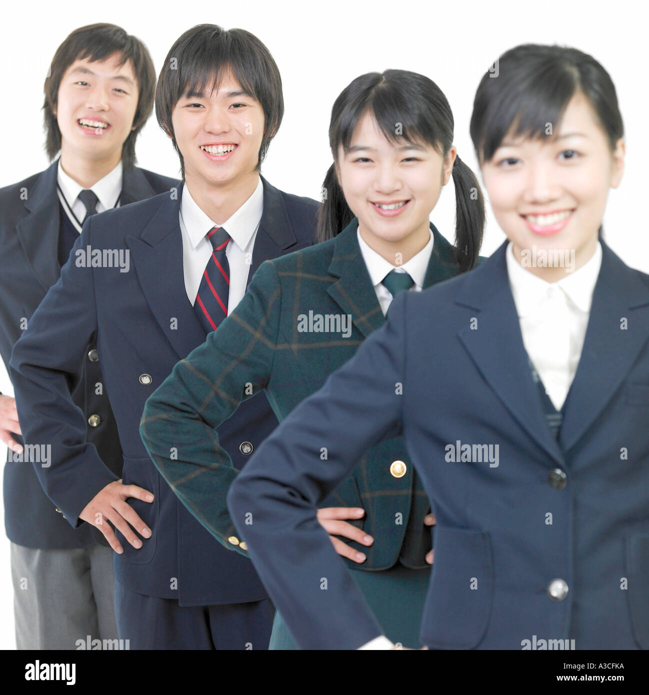 Four students are standing in a row and putting their hands on their ...