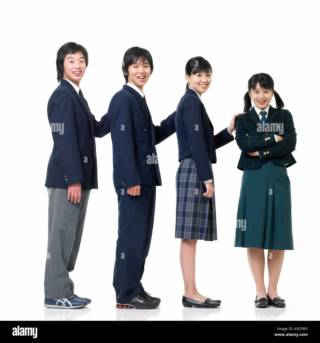 Four students are standing in a row and putting their one hand on the ...