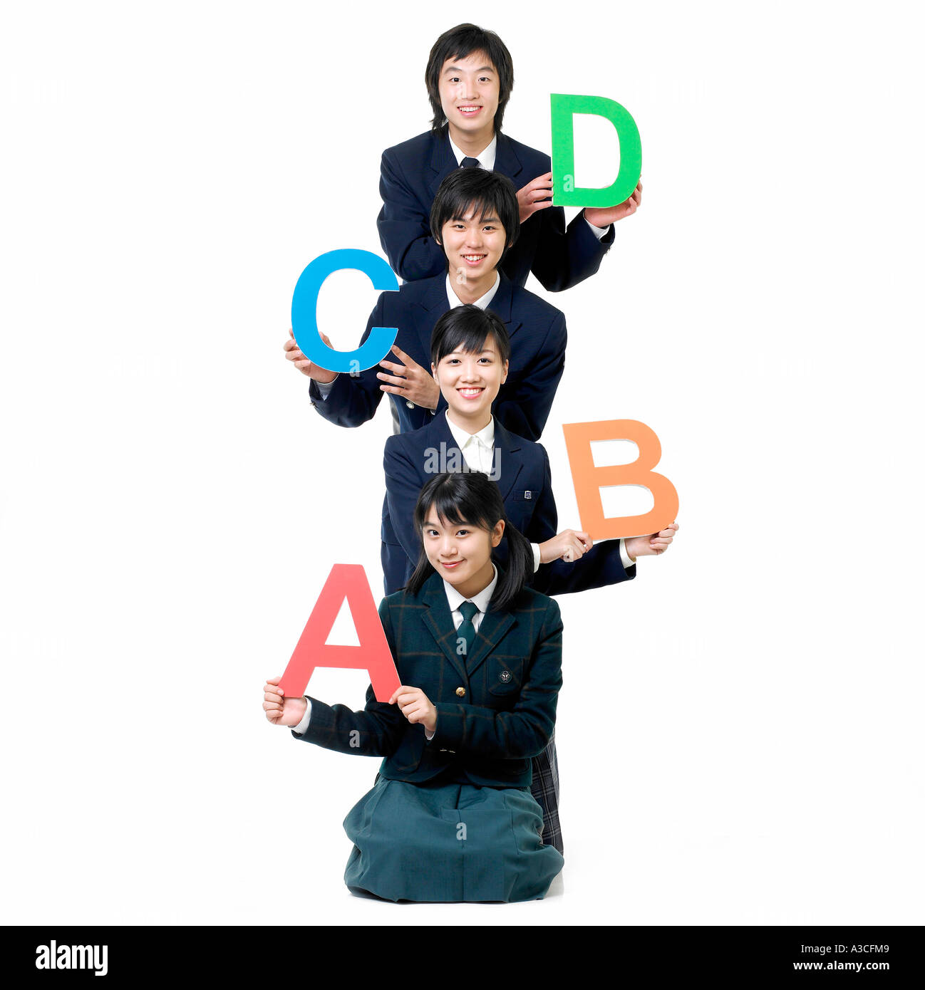 Teens in uniform with Alphabet letters Stock Photo - Alamy