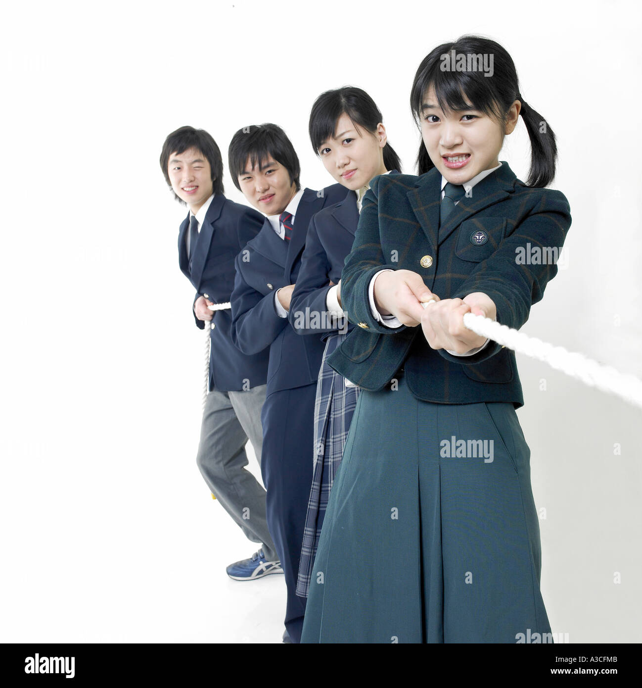 Four students are pulling a rope Stock Photo - Alamy