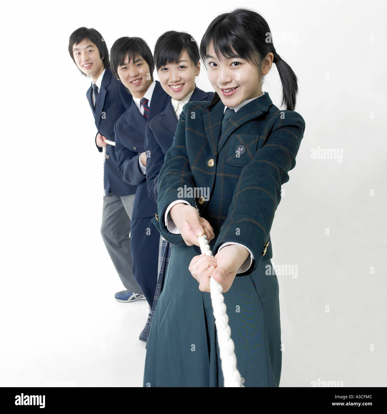 Students in school uniforms are pulling a rope together Stock Photo - Alamy