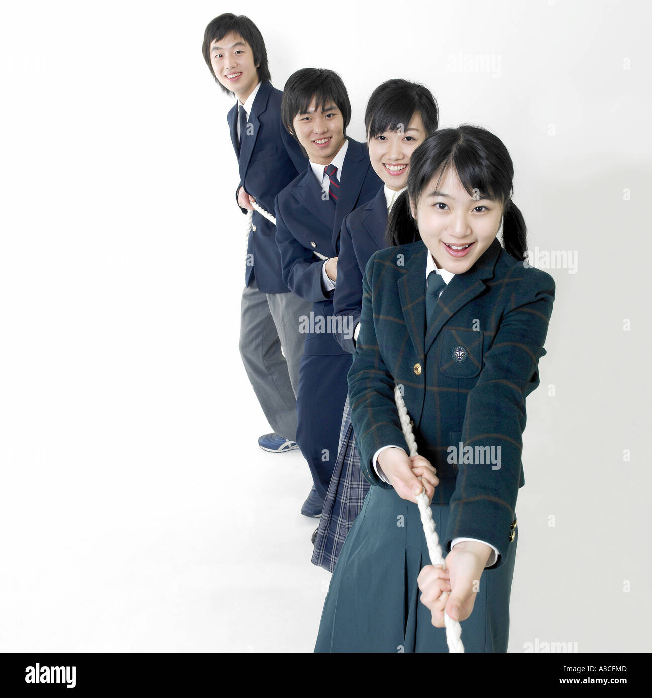 Four students are pulling a rope together Stock Photo - Alamy