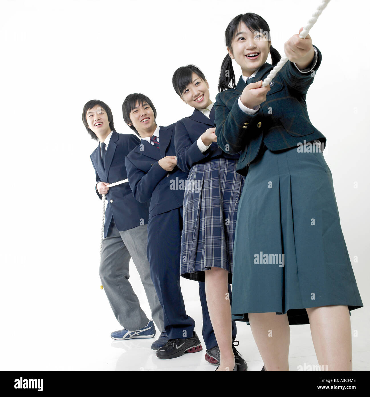 Four students are pulling a rope, smiling Stock Photo - Alamy