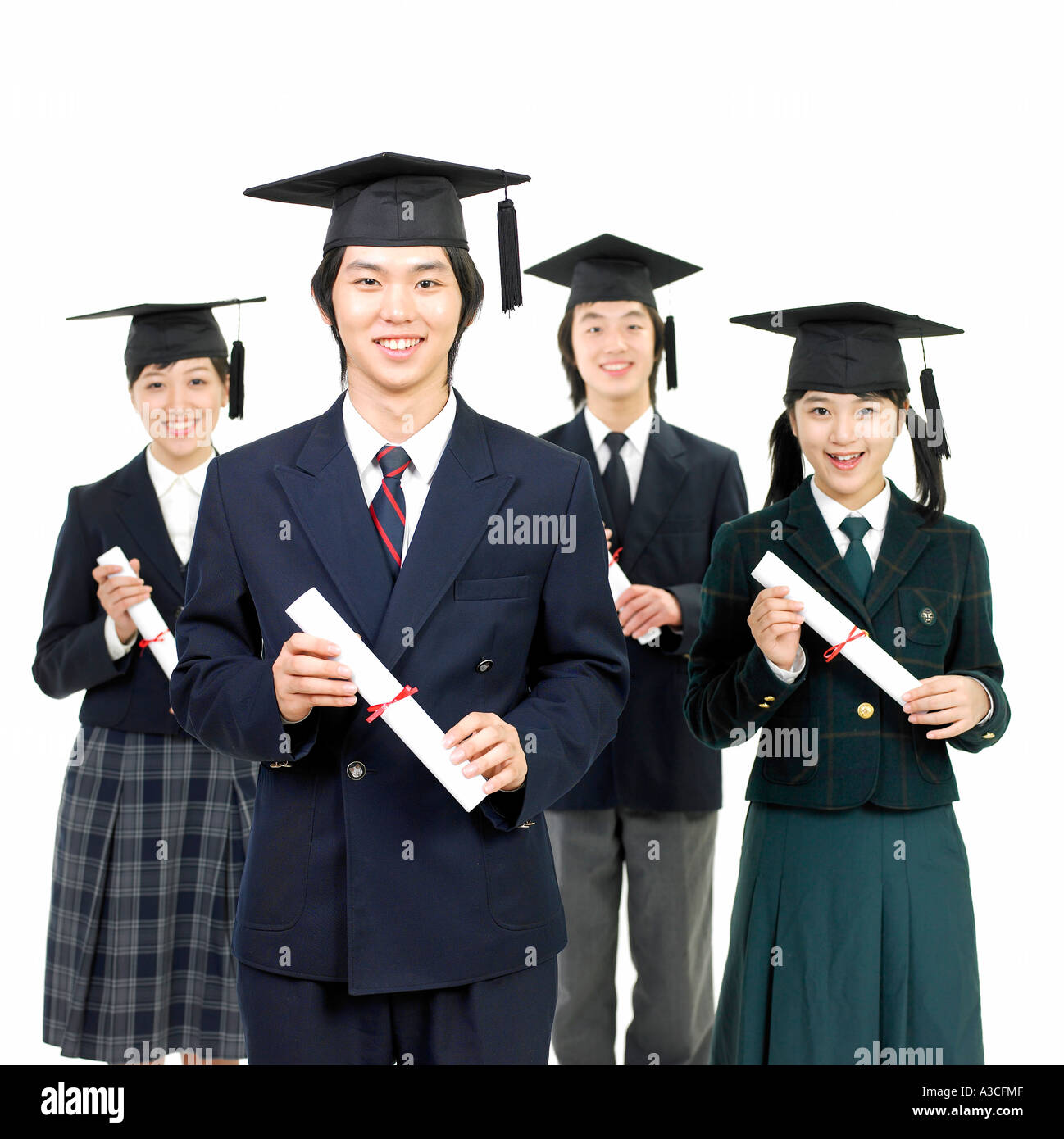 Four students are wearing graduation caps and holding a diploma Stock ...