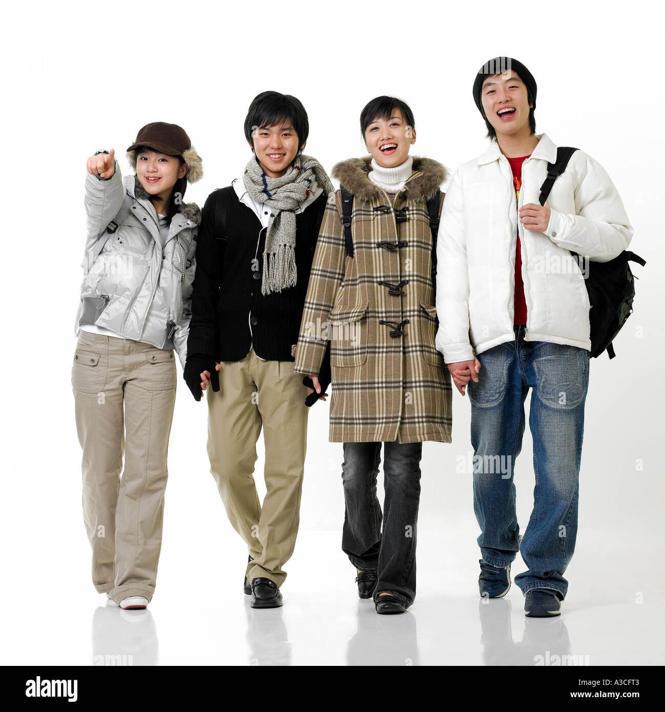 Four teenagers dressed warm are walking and smiling Stock Photo - Alamy