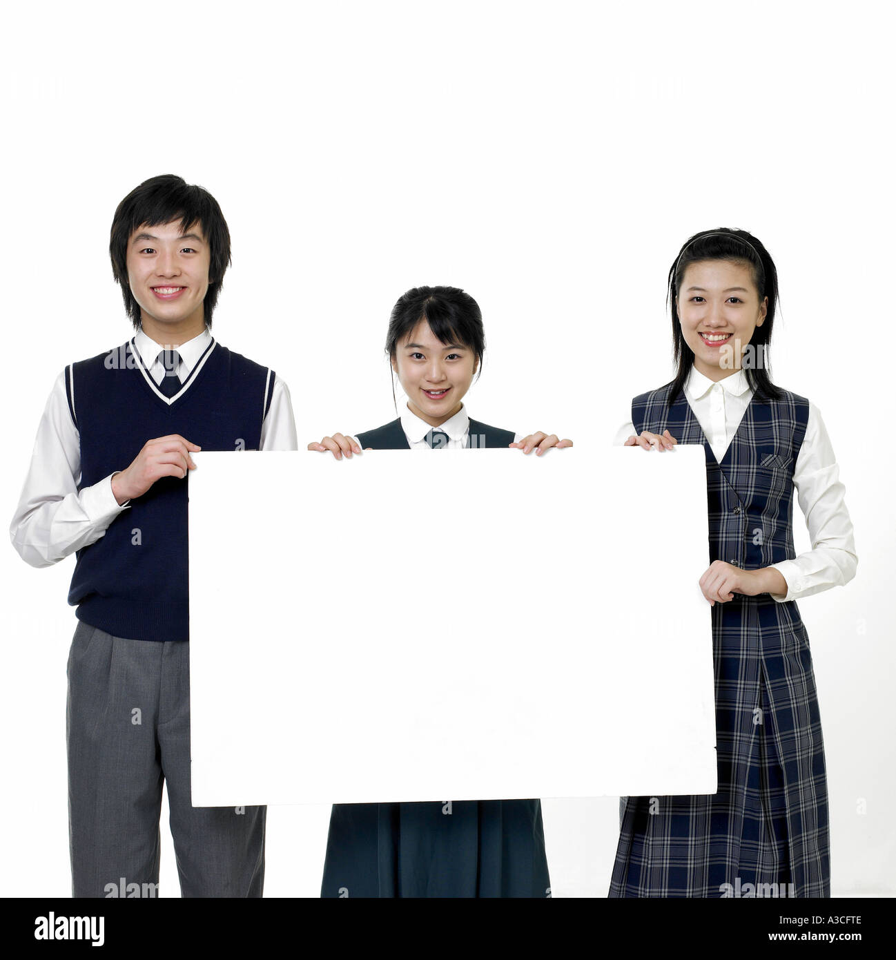Three students are holding white paper, smiling Stock Photo - Alamy