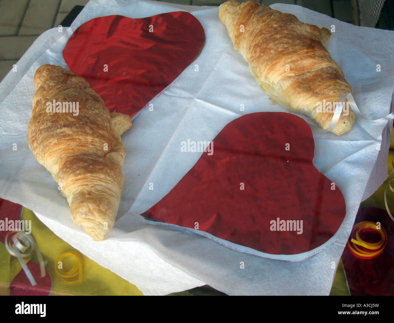 Two croissant in window display with paper hearts Stock Photo - Alamy