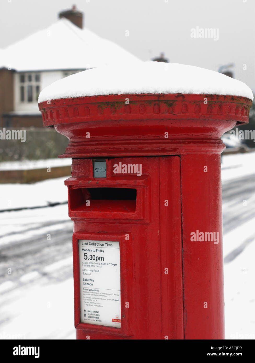 a snow capped red postbox in a suburban street in Thames Ditton Surrey ...