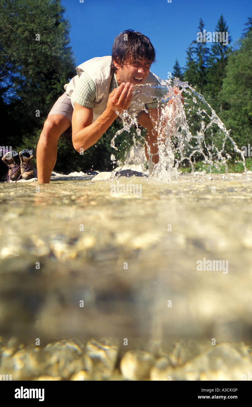 man refreshs himself at a river Stock Photo - Alamy